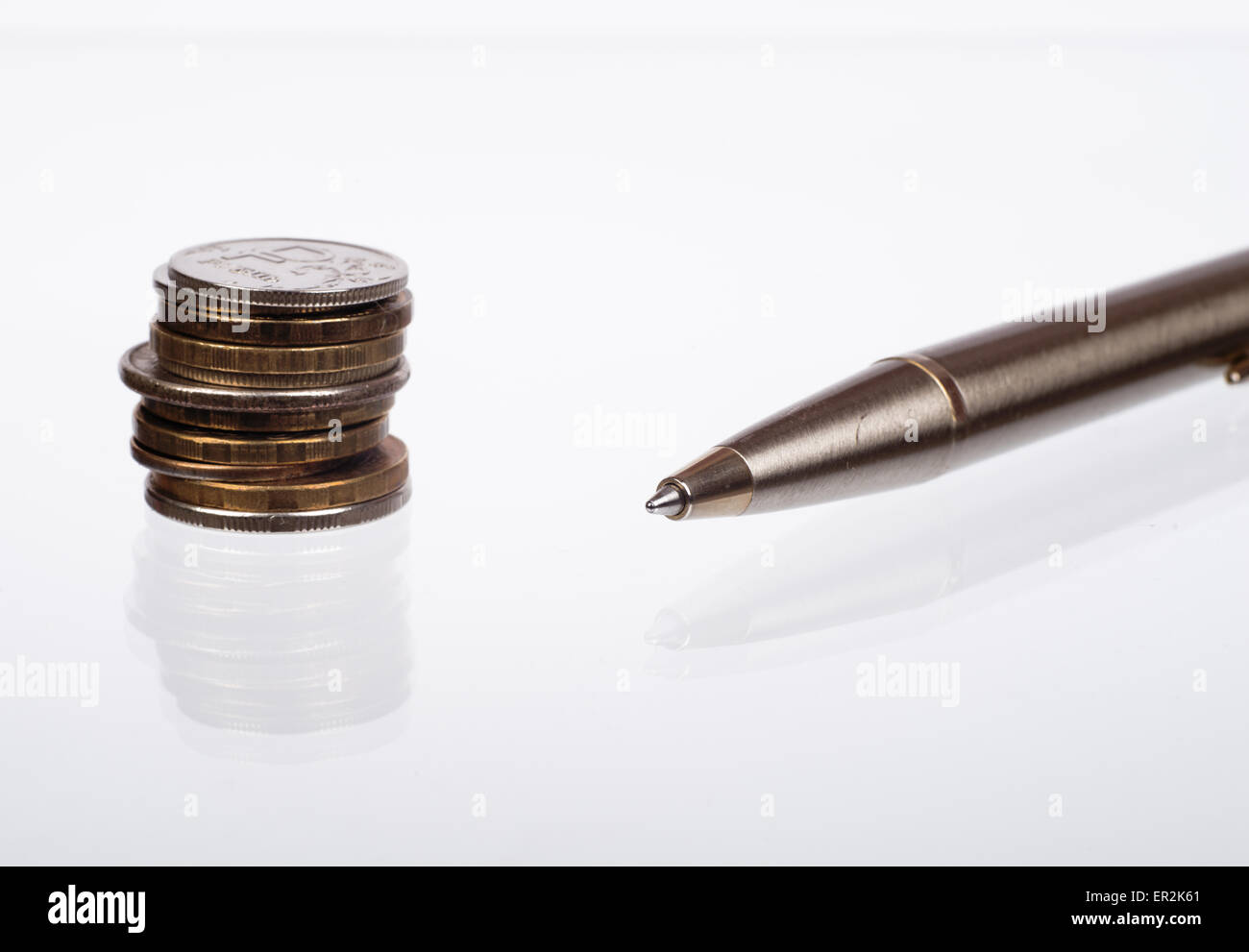 Pen with coins Stock Photo - Alamy