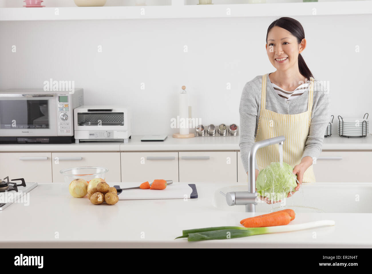 Woman washing cabbage in an open kitchen Stock Photo - Alamy