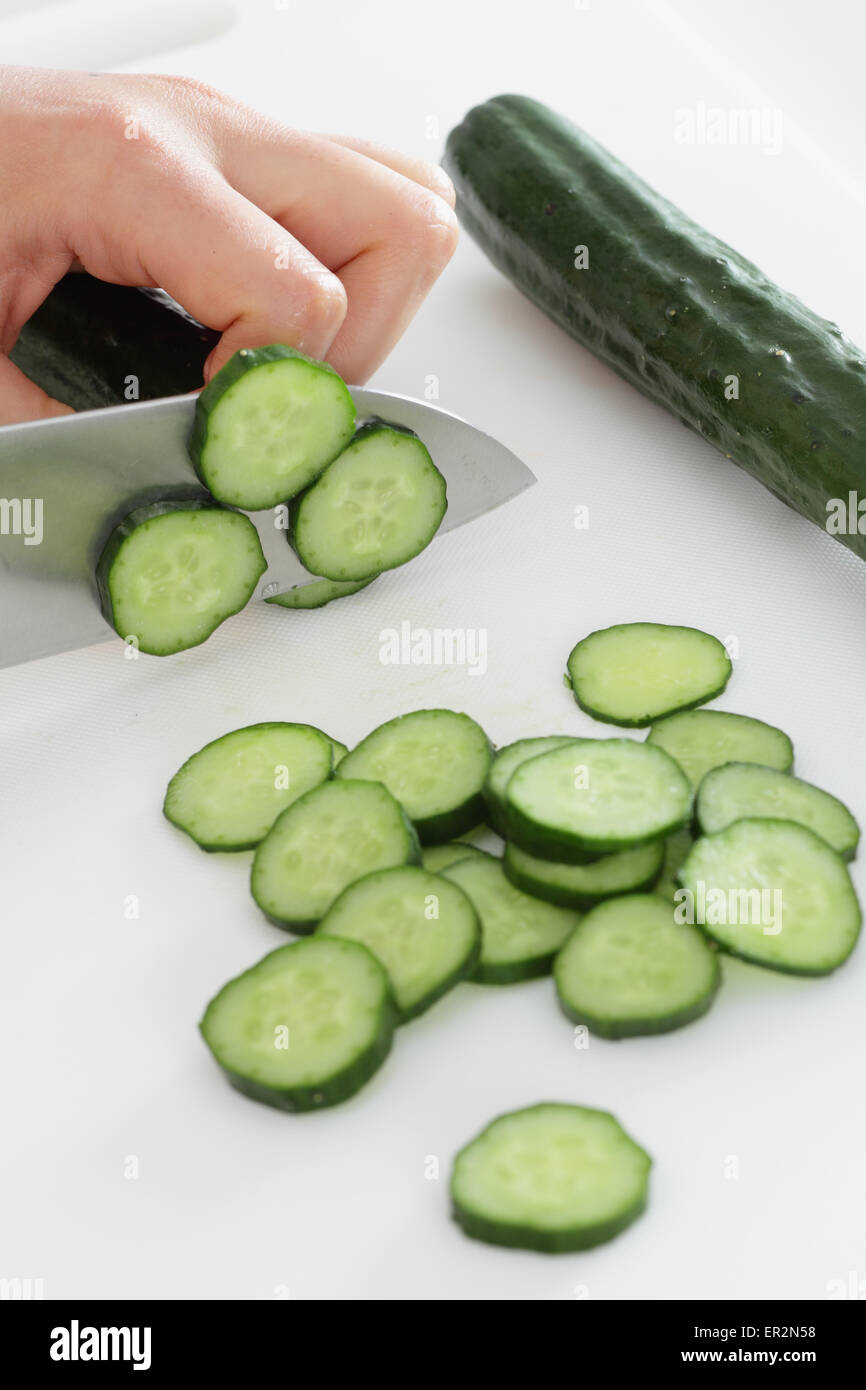 Close up of woman's hands slicing cucumbers with a kitchen knife Stock ...