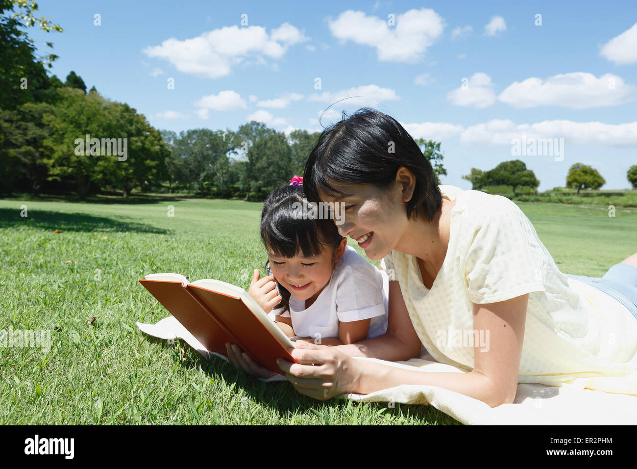 Japanese mother and daughter reading a book in a city park Stock Photo - Alamy