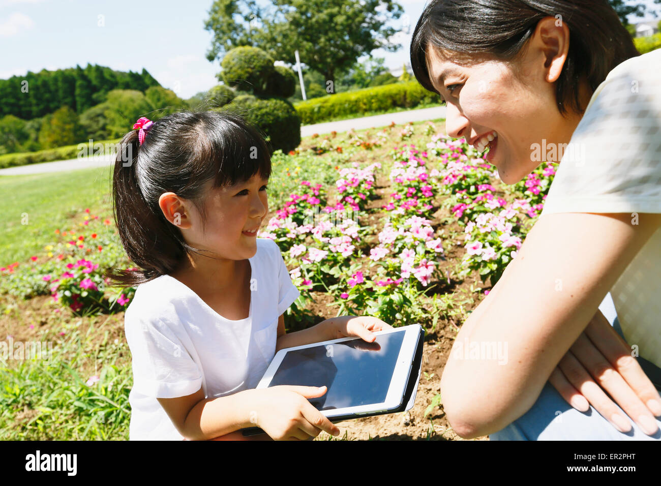 Japanese mother and daughter with tablet in a city park Stock Photo - Alamy