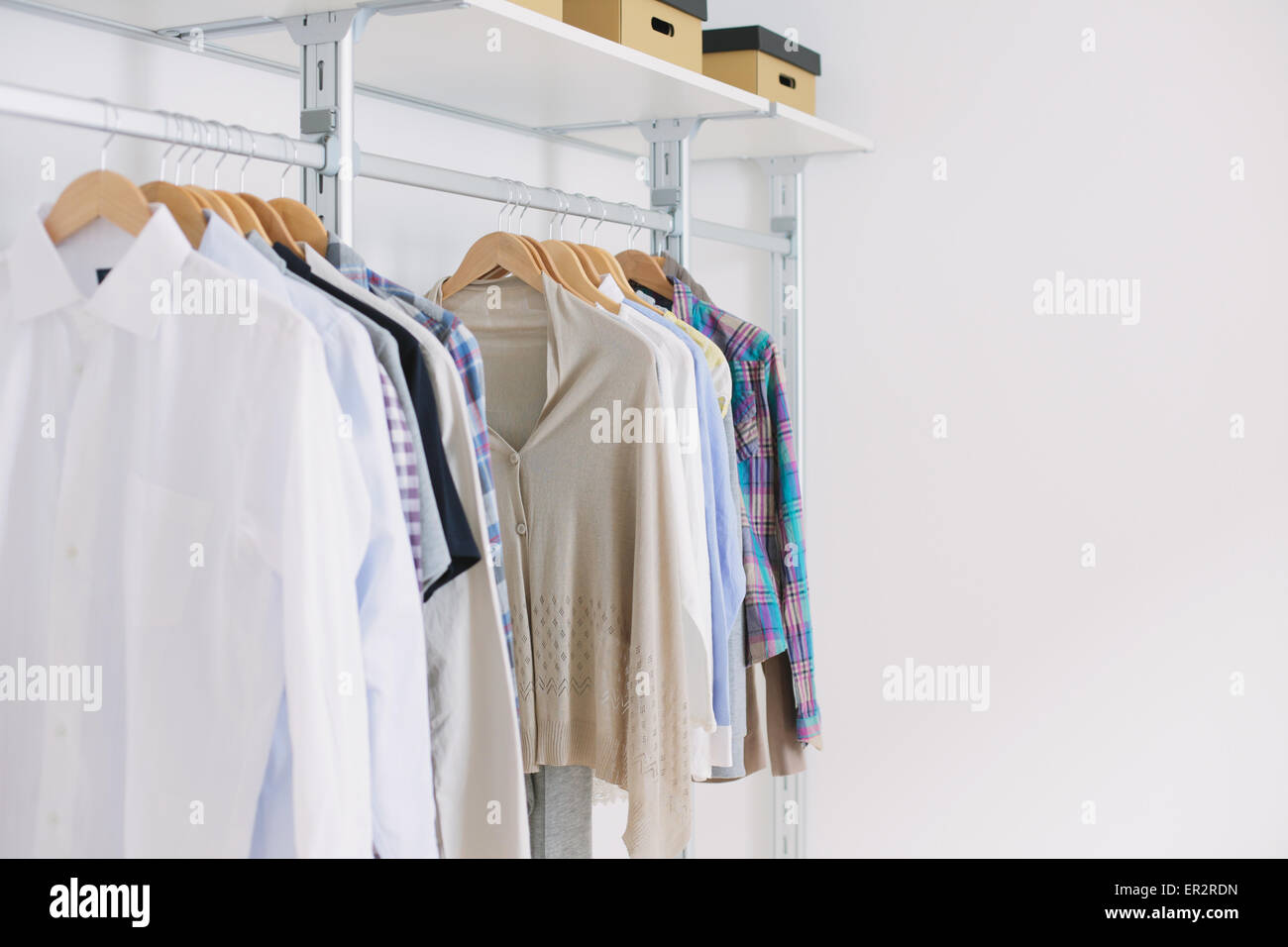 Shirts and sweaters hanging in a walk in closet Stock Photo - Alamy