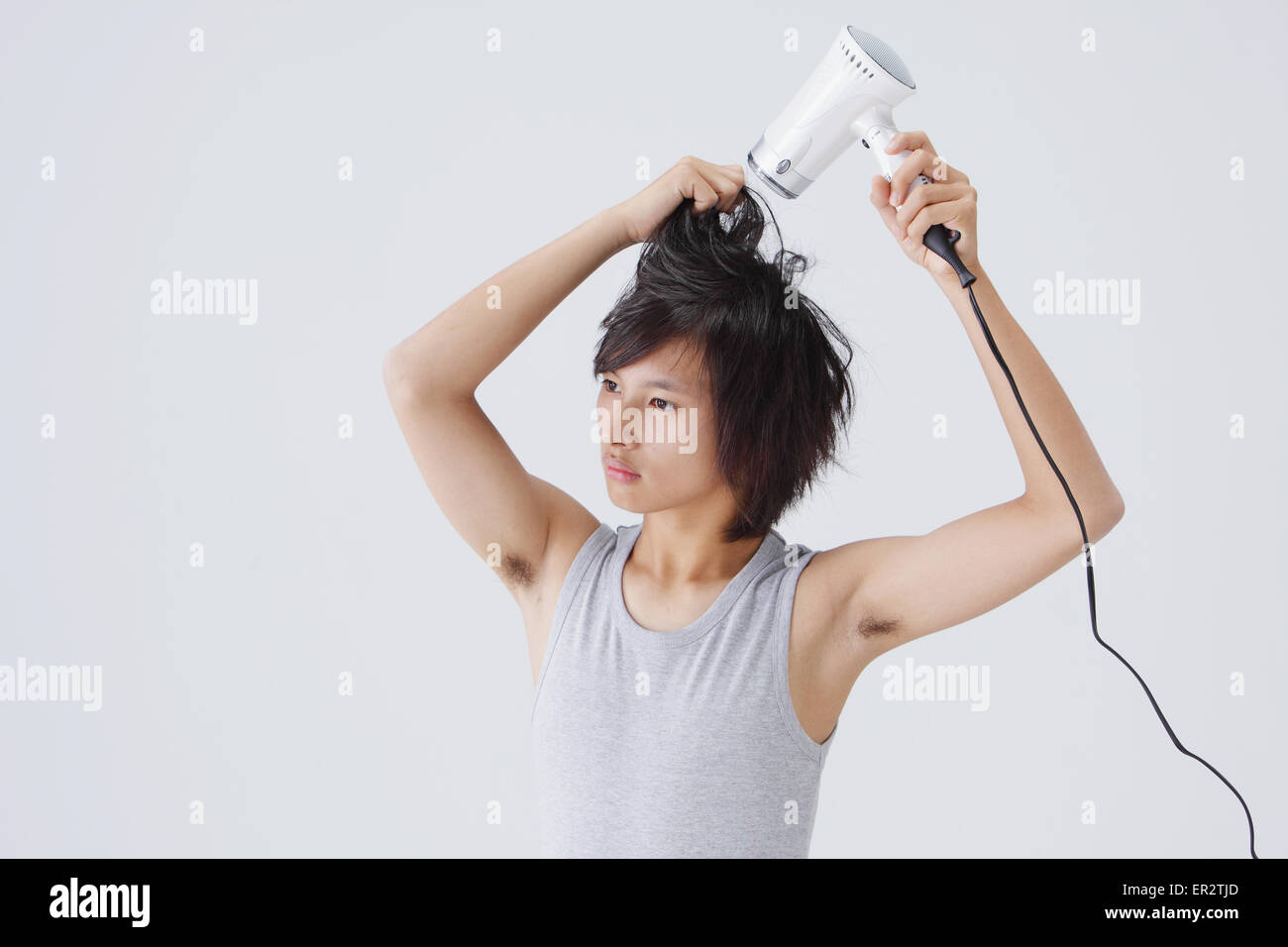 Portrait of young man drying his hair Stock Photo - Alamy