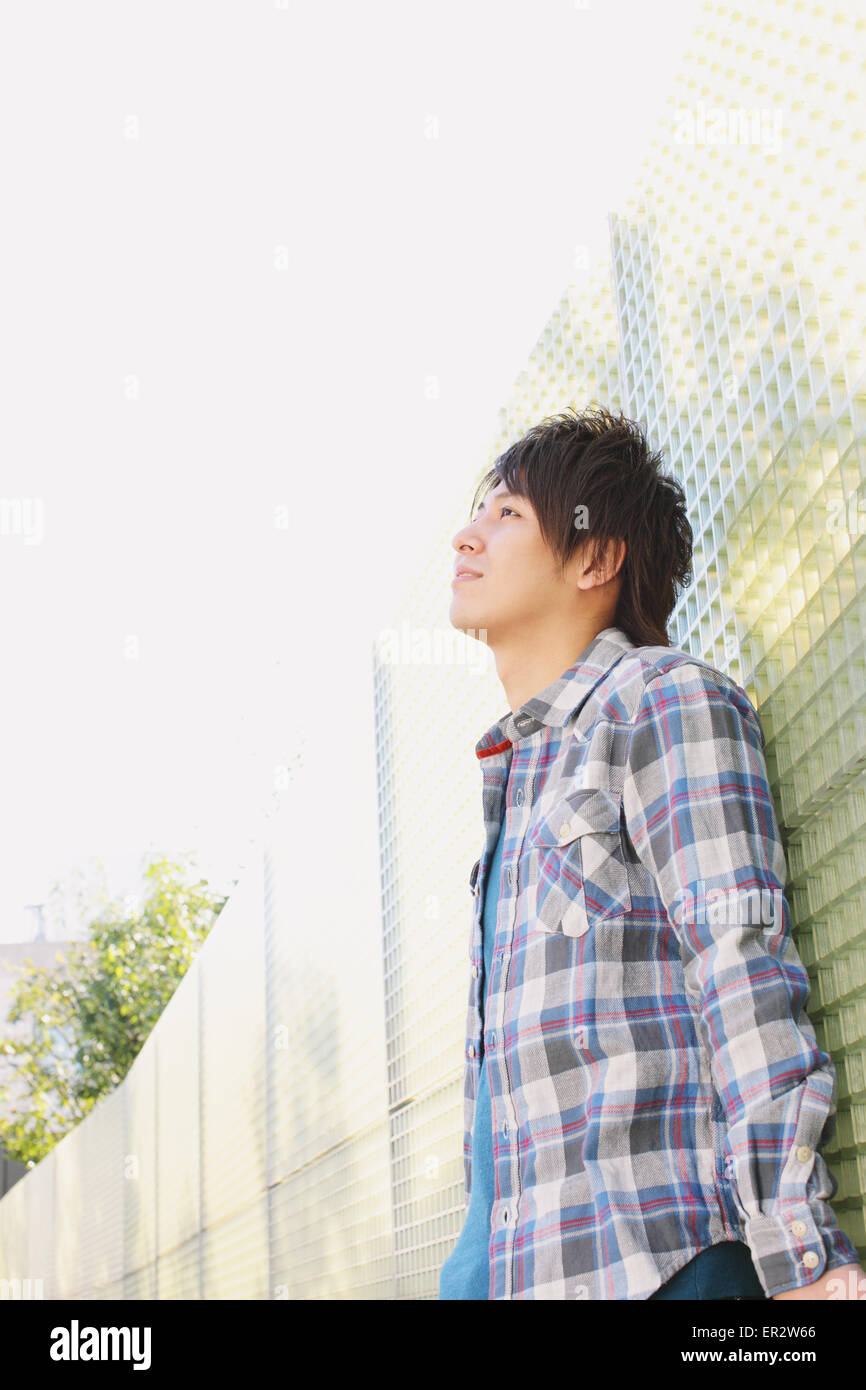 Young man leaning against a wall Stock Photo - Alamy