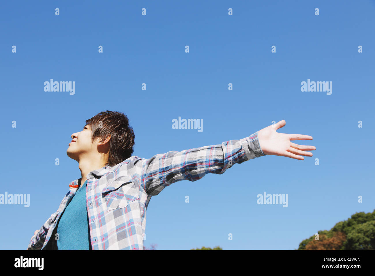 Young man spreading arms Stock Photo - Alamy