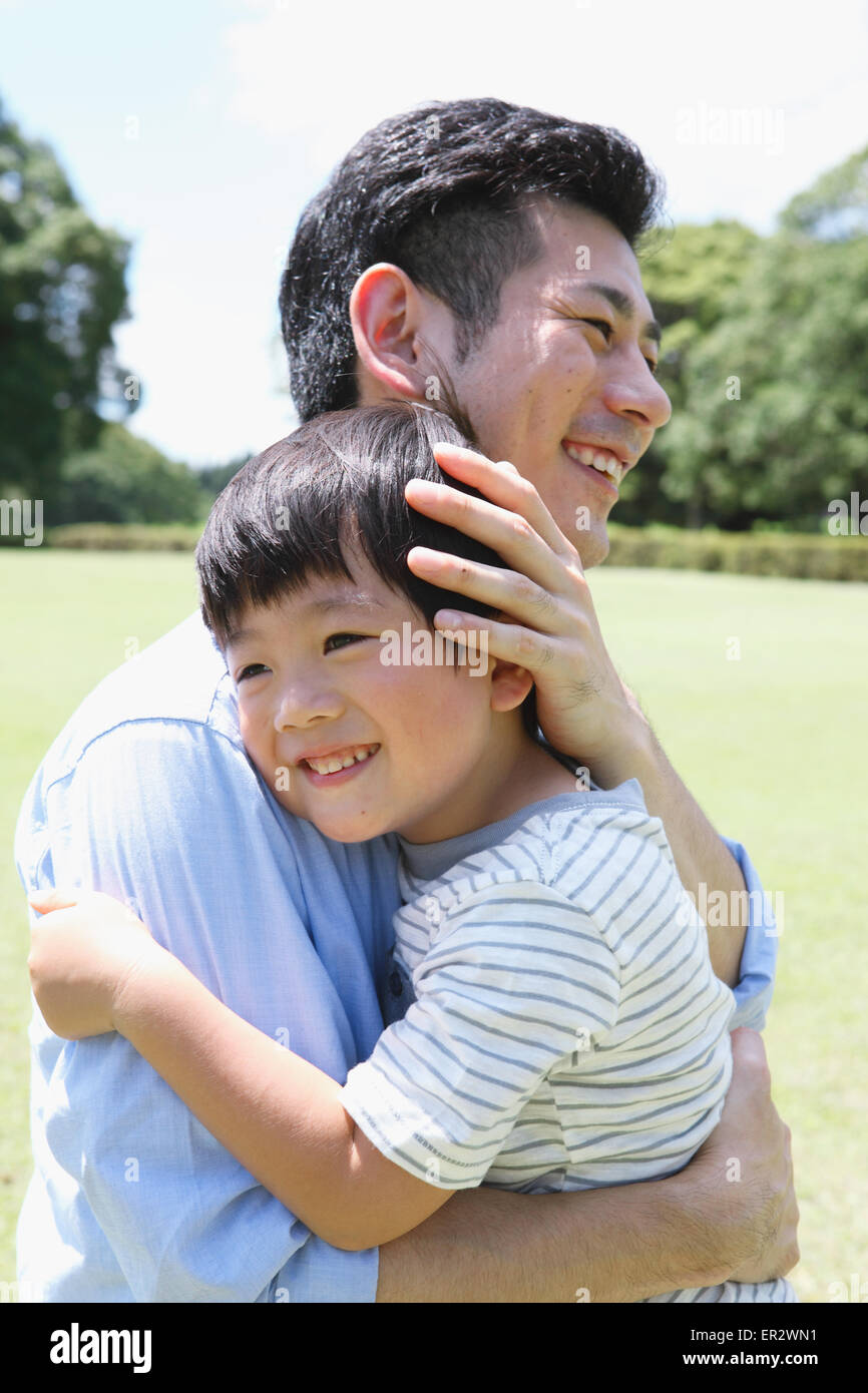 Happy Japanese father and son hugging in a city park Stock Photo - Alamy