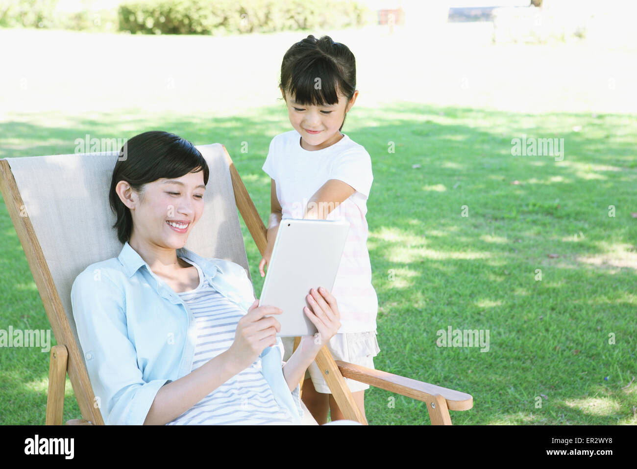 Japanese mother and daughter with tablet in a city park Stock Photo - Alamy