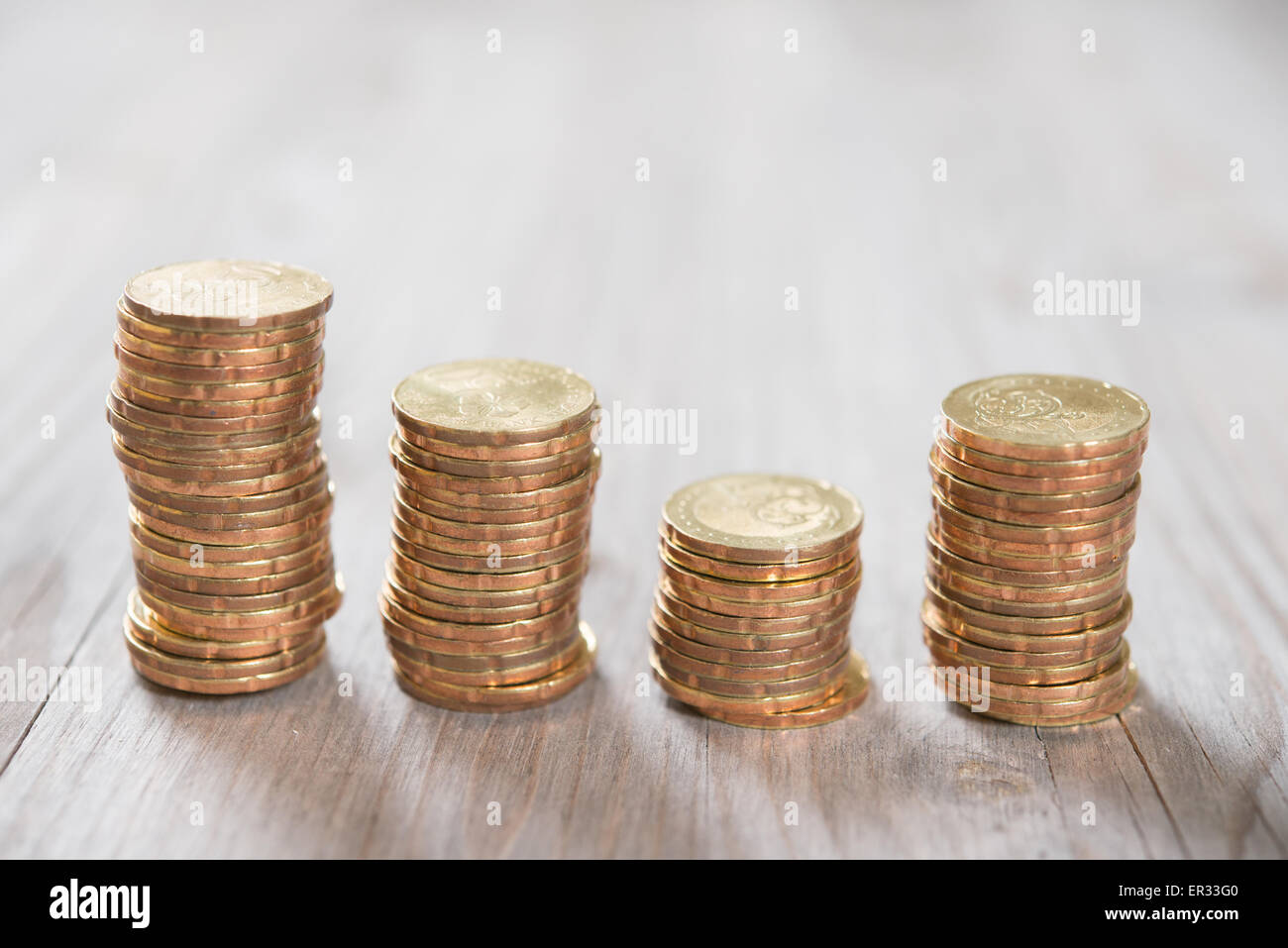 Coins stack in row on wooden background, financial concept. Focus on ...