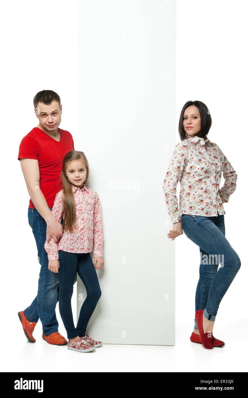 Happy family standing behind billboard Stock Photo - Alamy