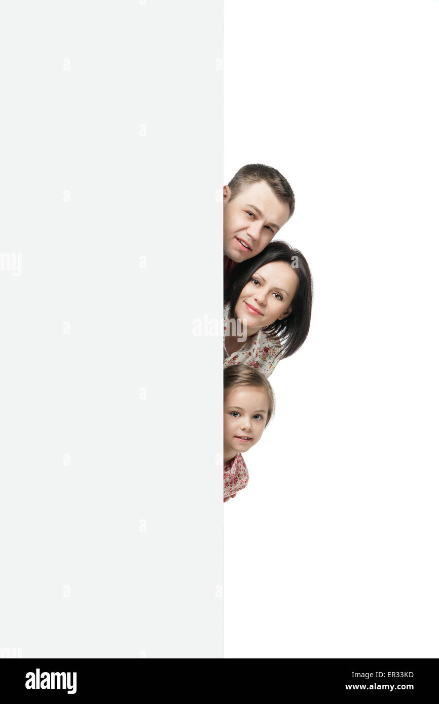 Happy family hiding behind billboard Stock Photo - Alamy