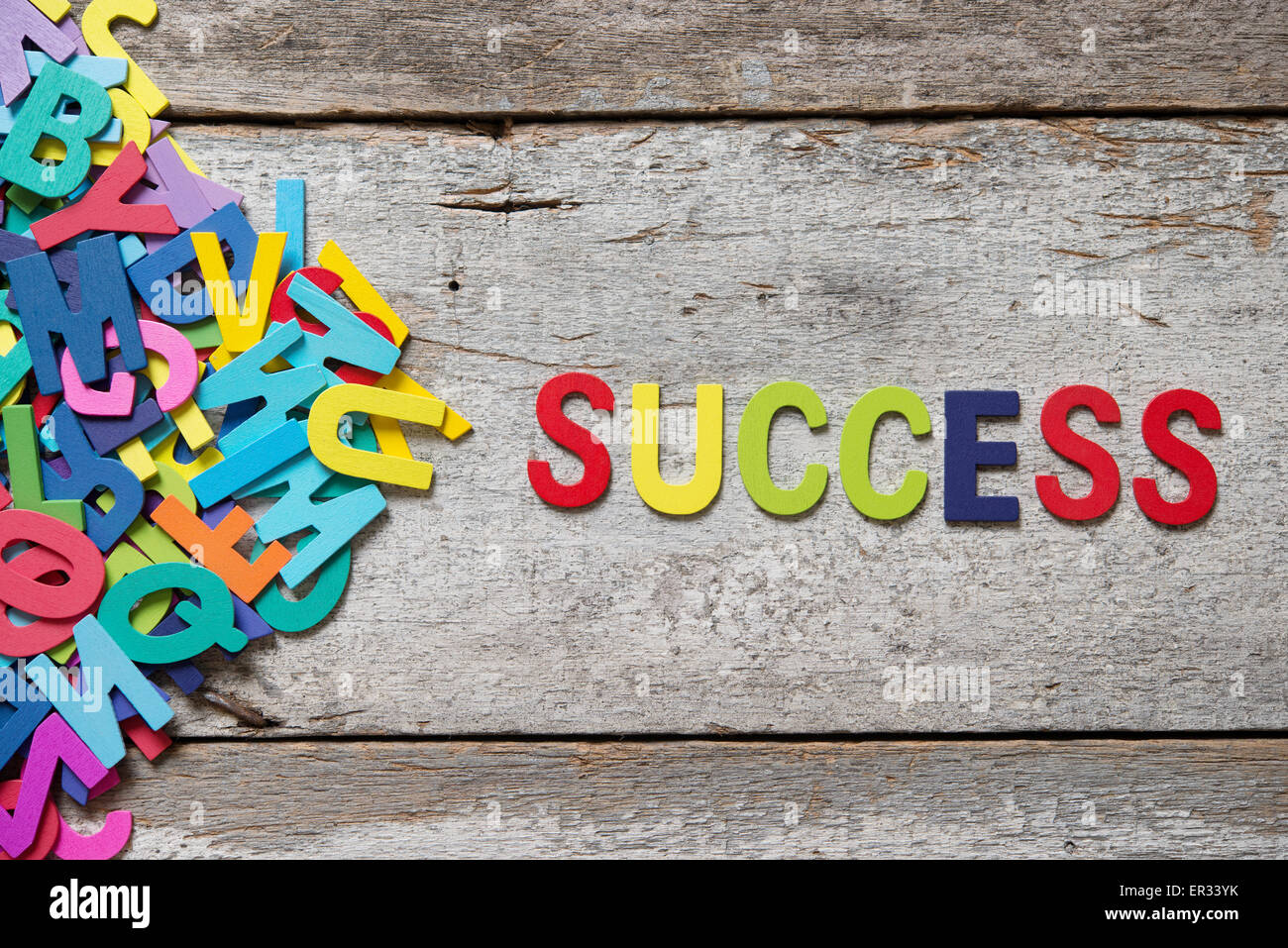 The colorful words "SUCCESS" made with wooden letters next to a pile of ...