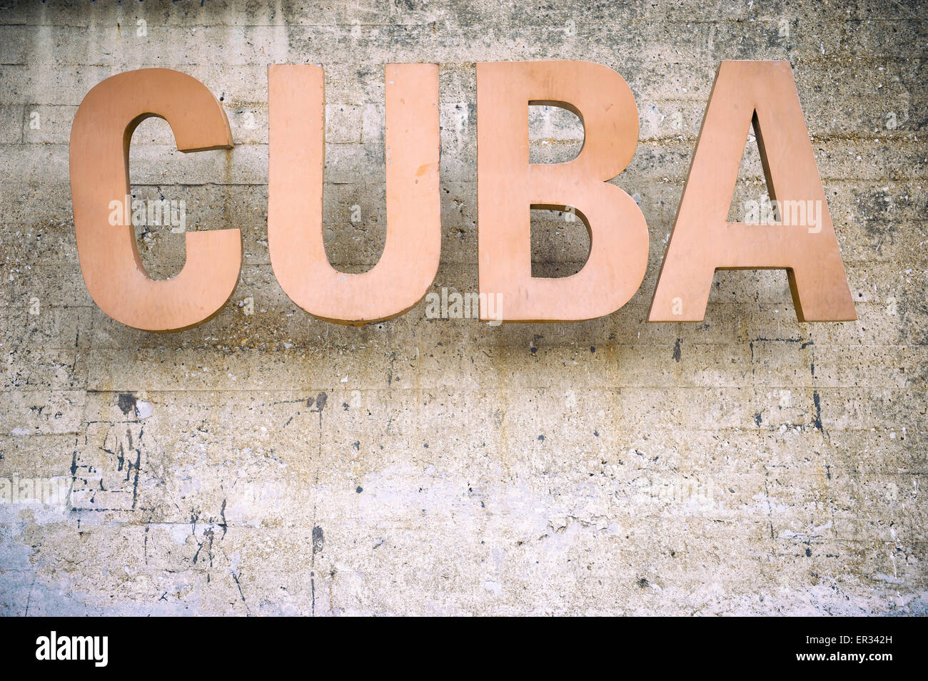 Cuba sign in capital letters hangs from weathered stone wall background ...