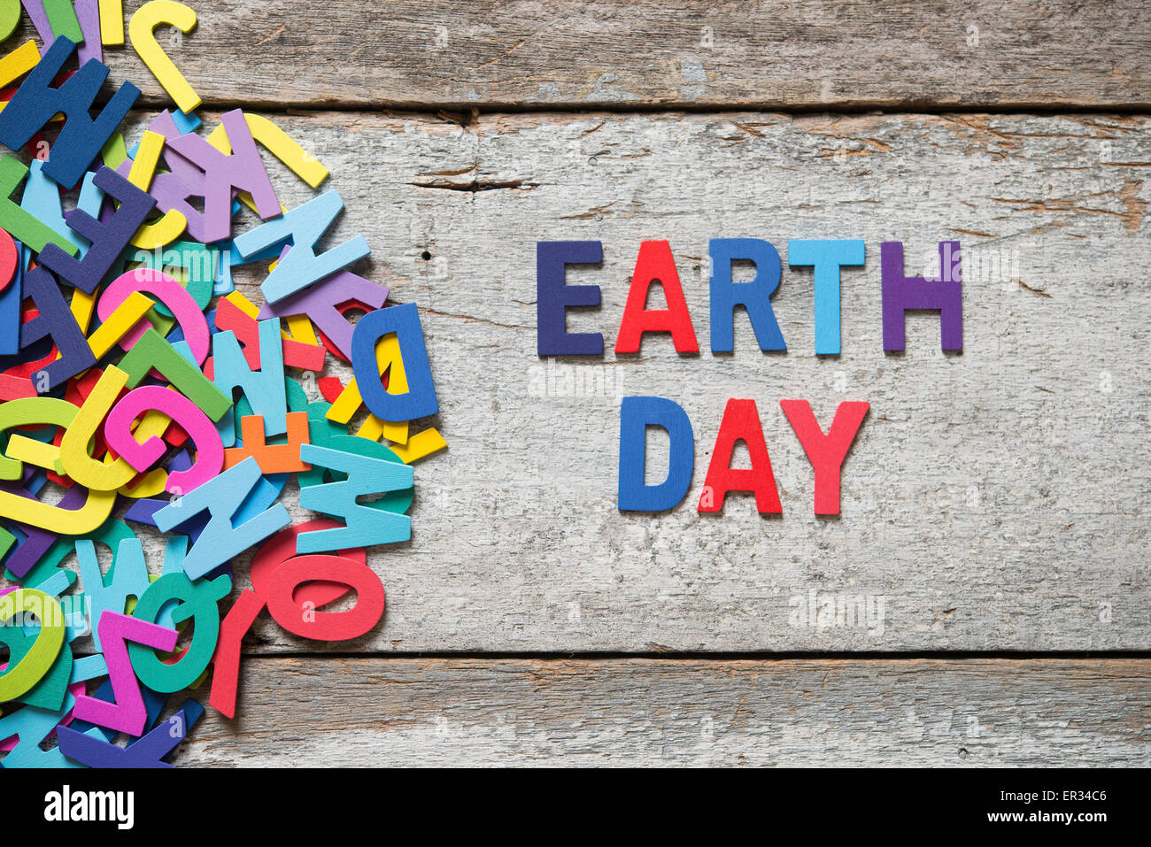 The colorful words "EARTH DAY" made with wooden letters next to a pile ...