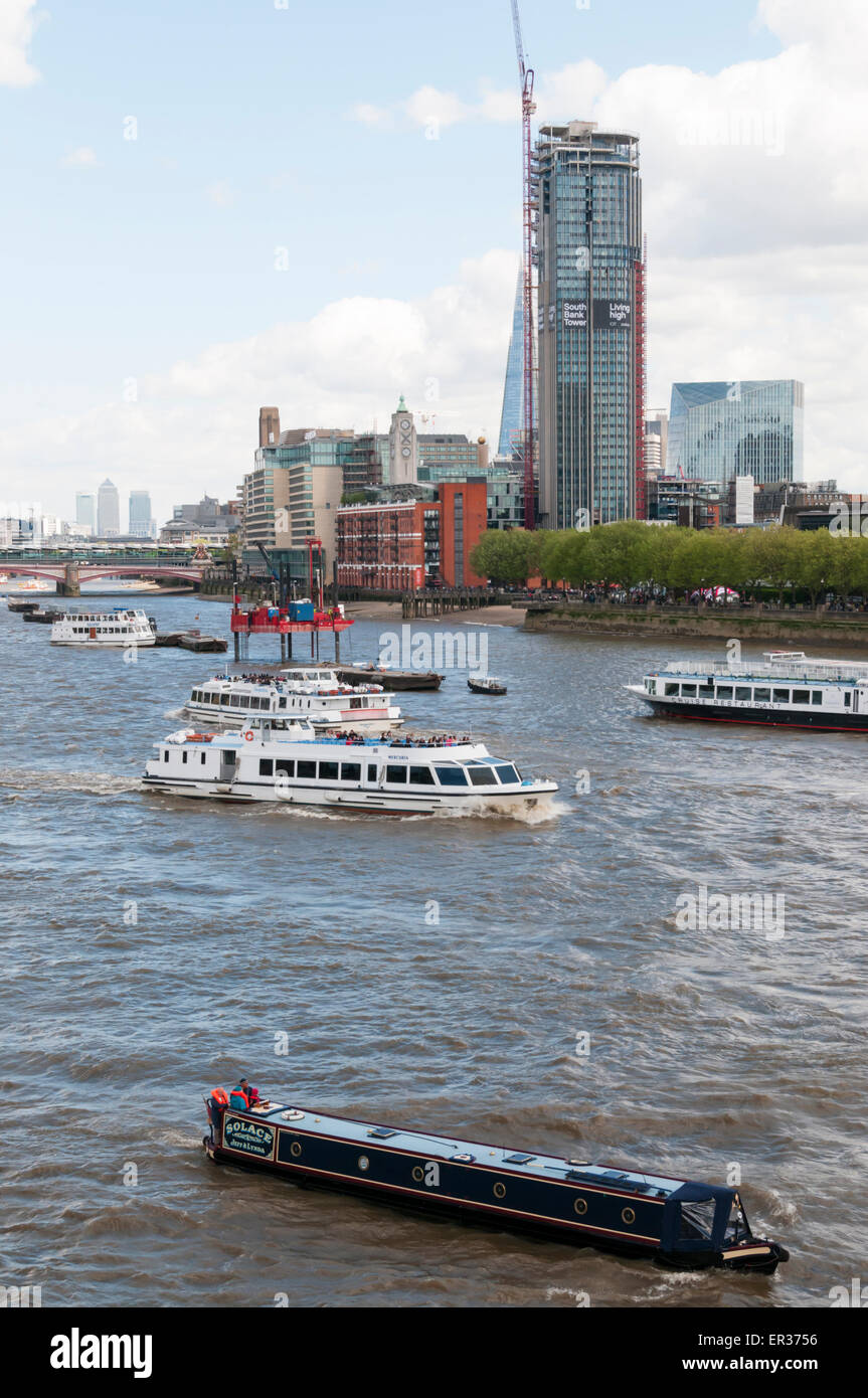 A canal narrowboat making its way inland up the River Thames through ...