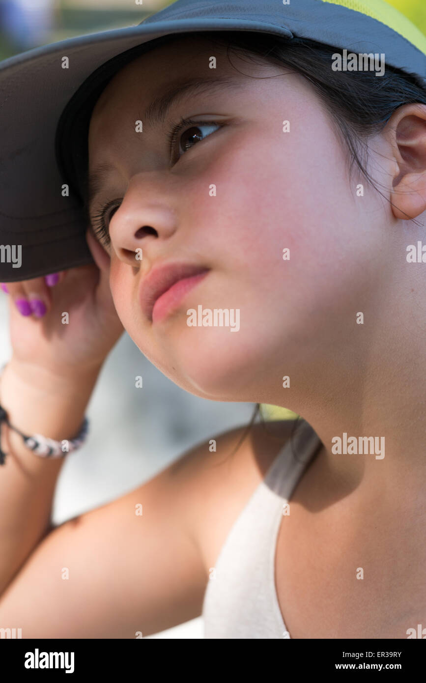 Portrait of a young girl in thought holding cap on head portrait model ...