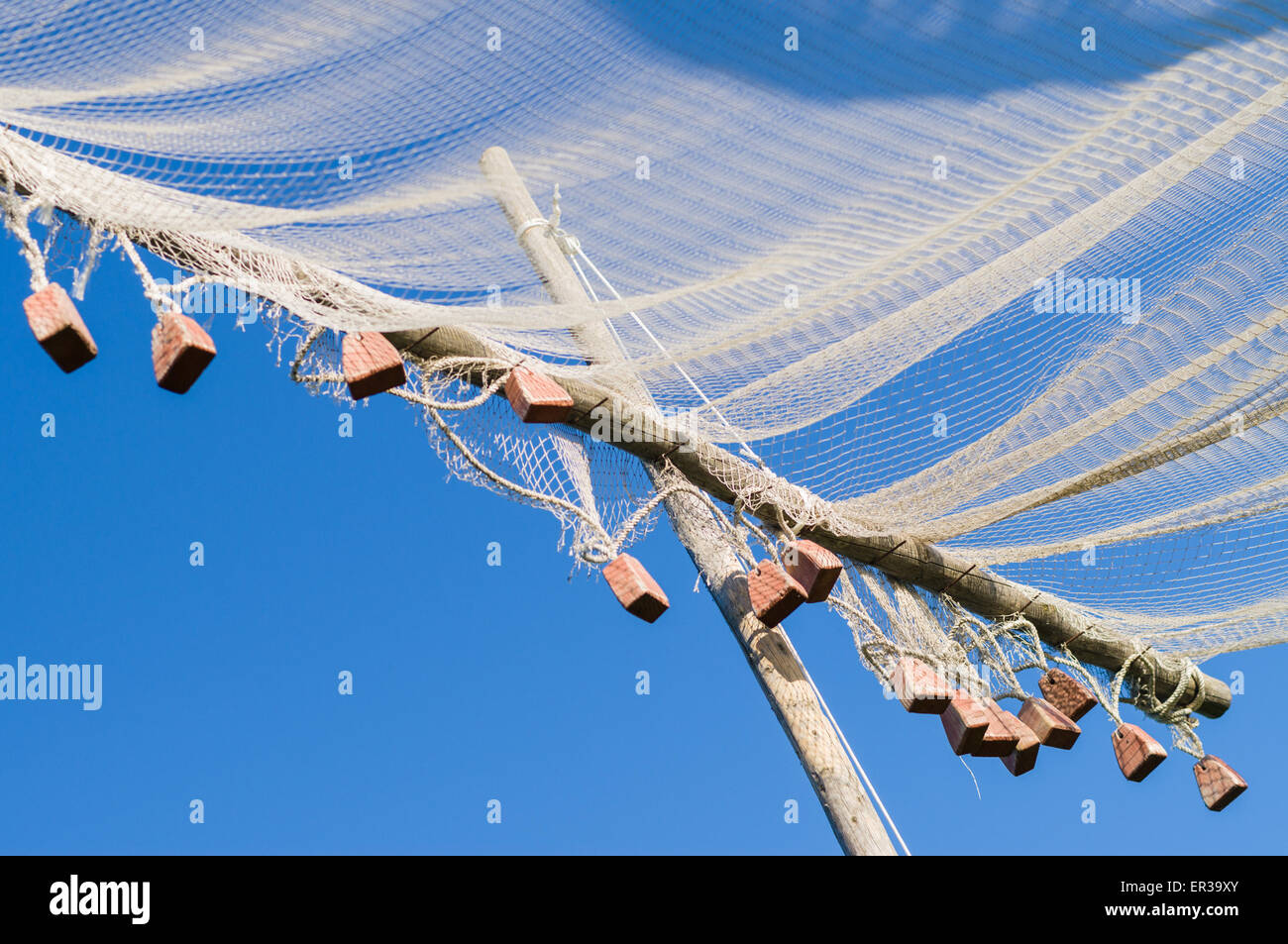 Closeup on old style fishing net hanging to dry under sun Stock Photo ...