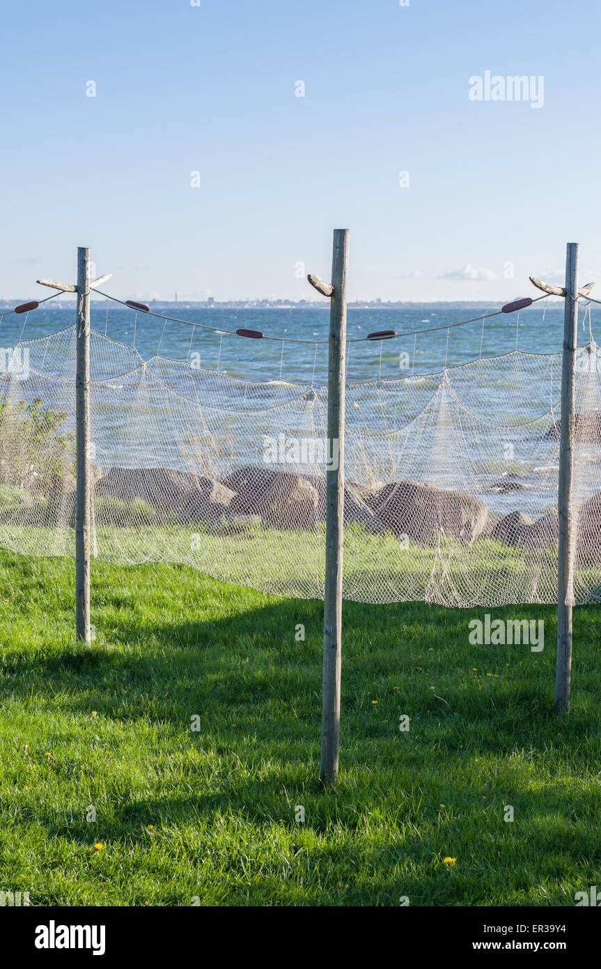 Old style fishing net hanging to dry near seashore Stock Photo - Alamy