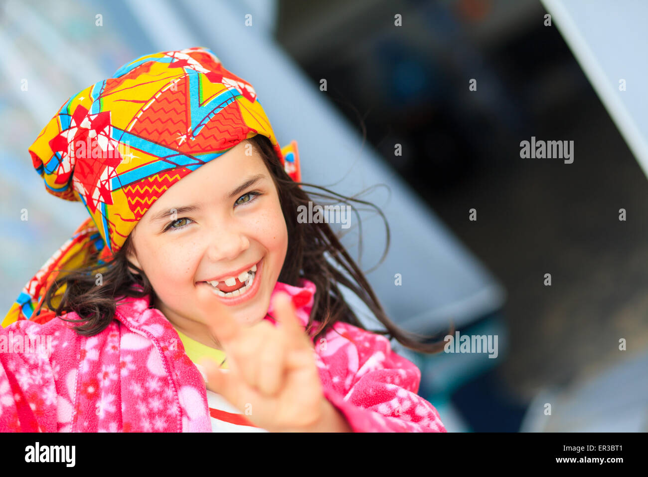 Portrait of a smiling girl gesturing horn sign Stock Photo - Alamy