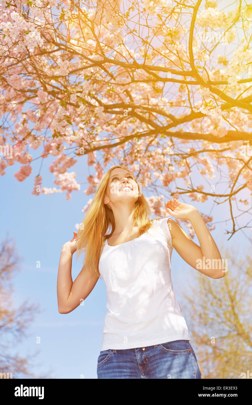Happy girl excited about sun and cherry blossom in spring Stock Photo ...