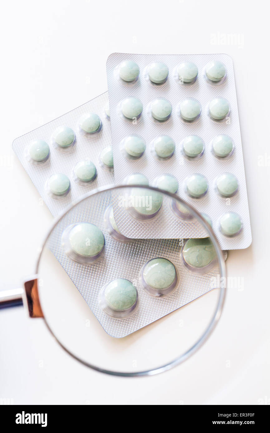 Medicine and magnifying glass Stock Photo - Alamy