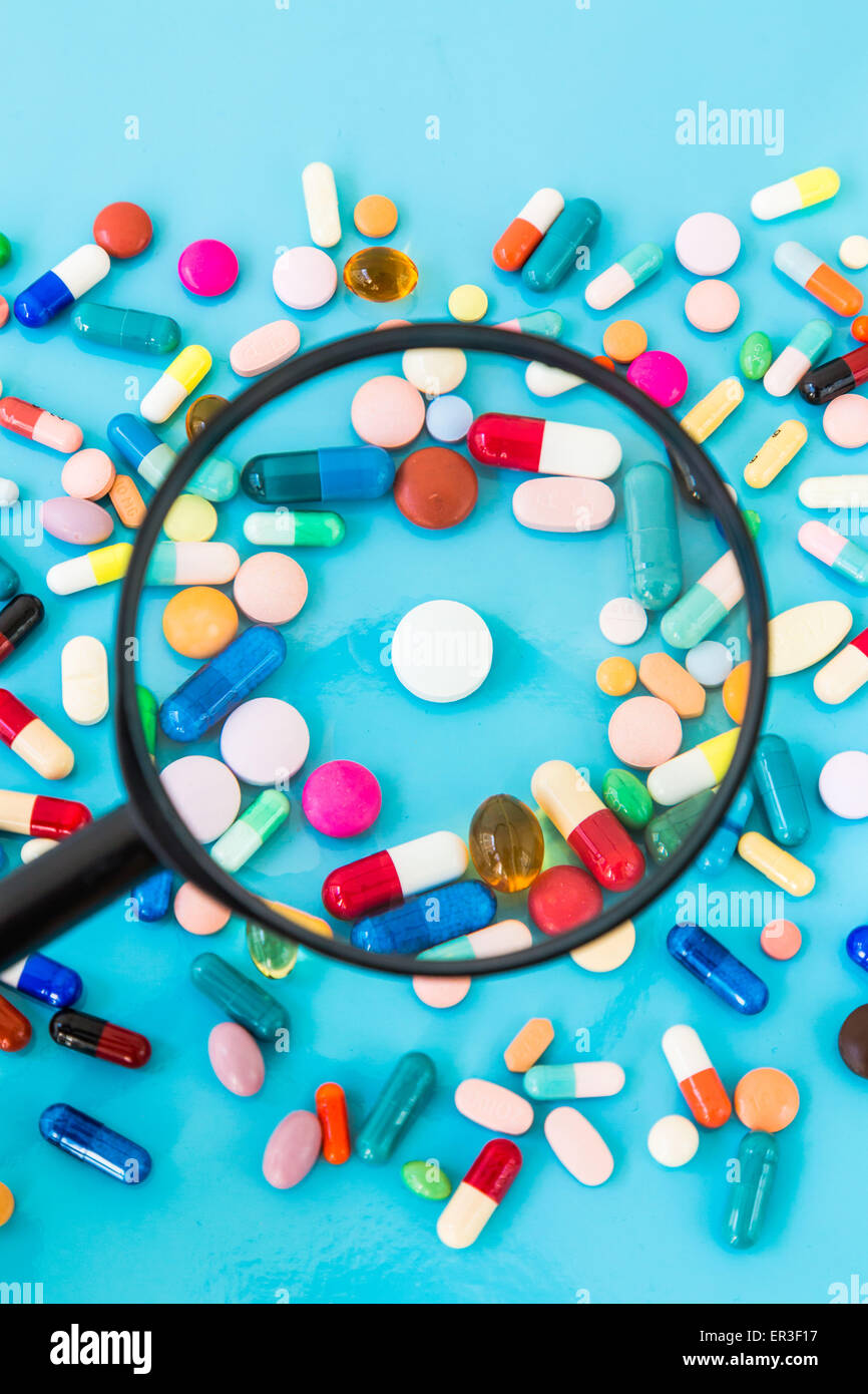 Medicine and magnifying glass Stock Photo - Alamy