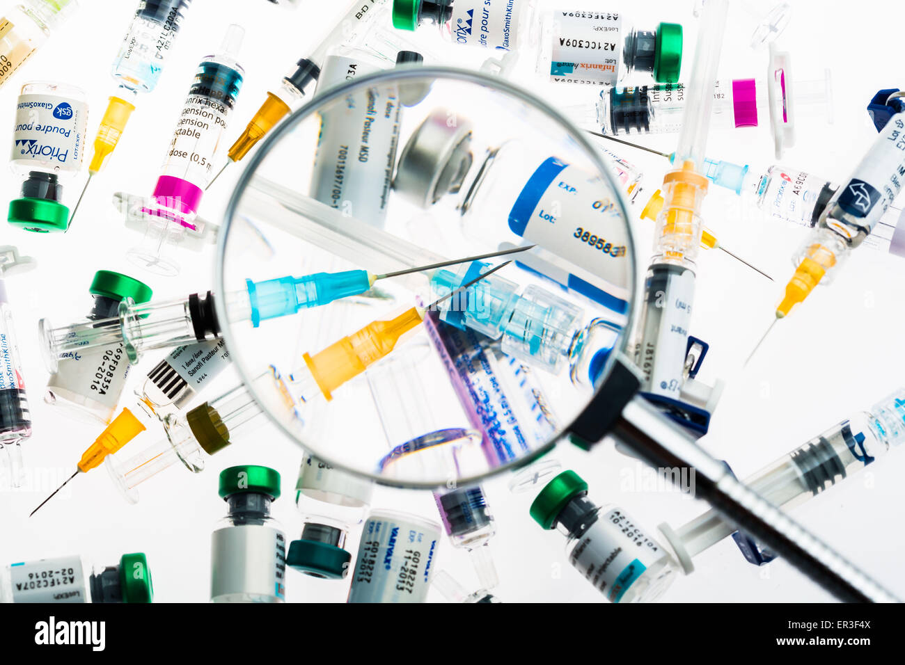 Syringe and magnifying glass Stock Photo - Alamy