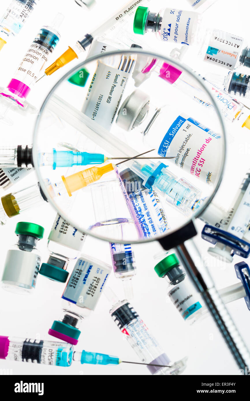 Syringe and magnifying glass Stock Photo - Alamy
