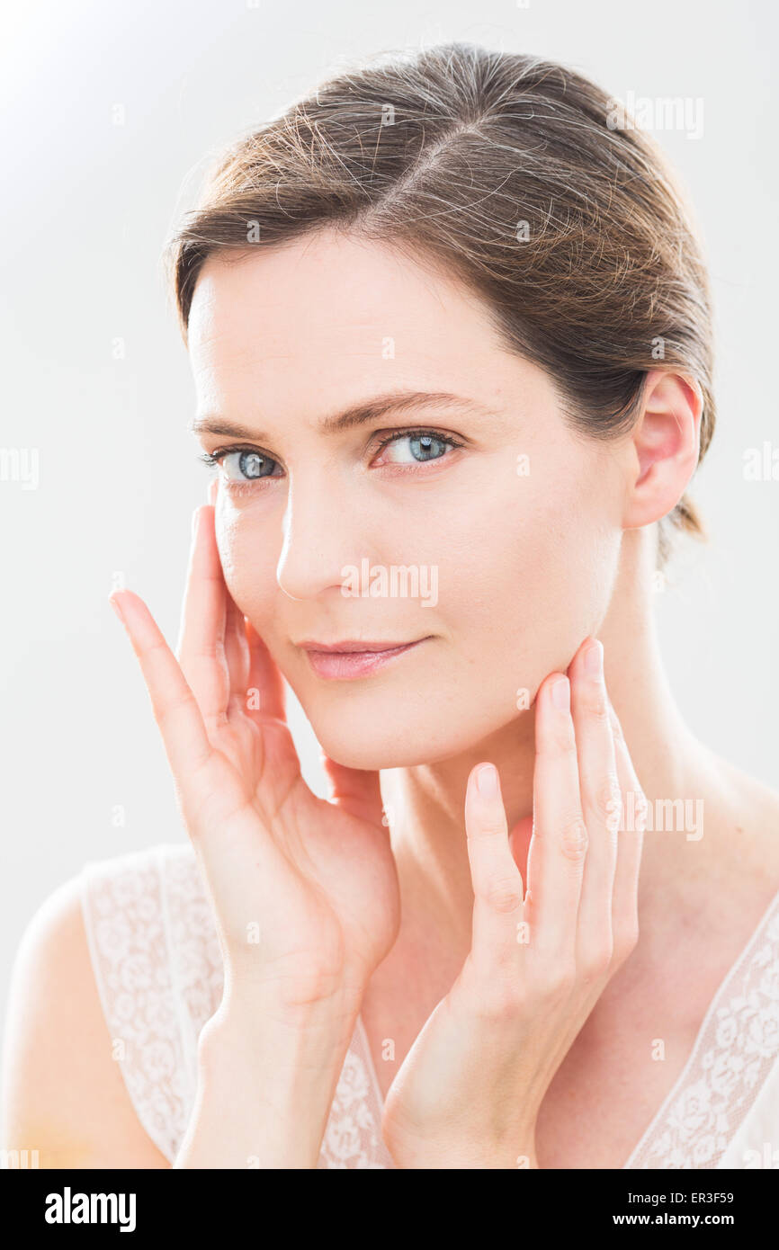 Woman touching face Stock Photo - Alamy
