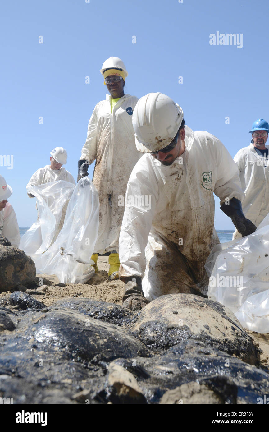 Cleanup crews remove oily sand during efforts to reduce damage from a ...