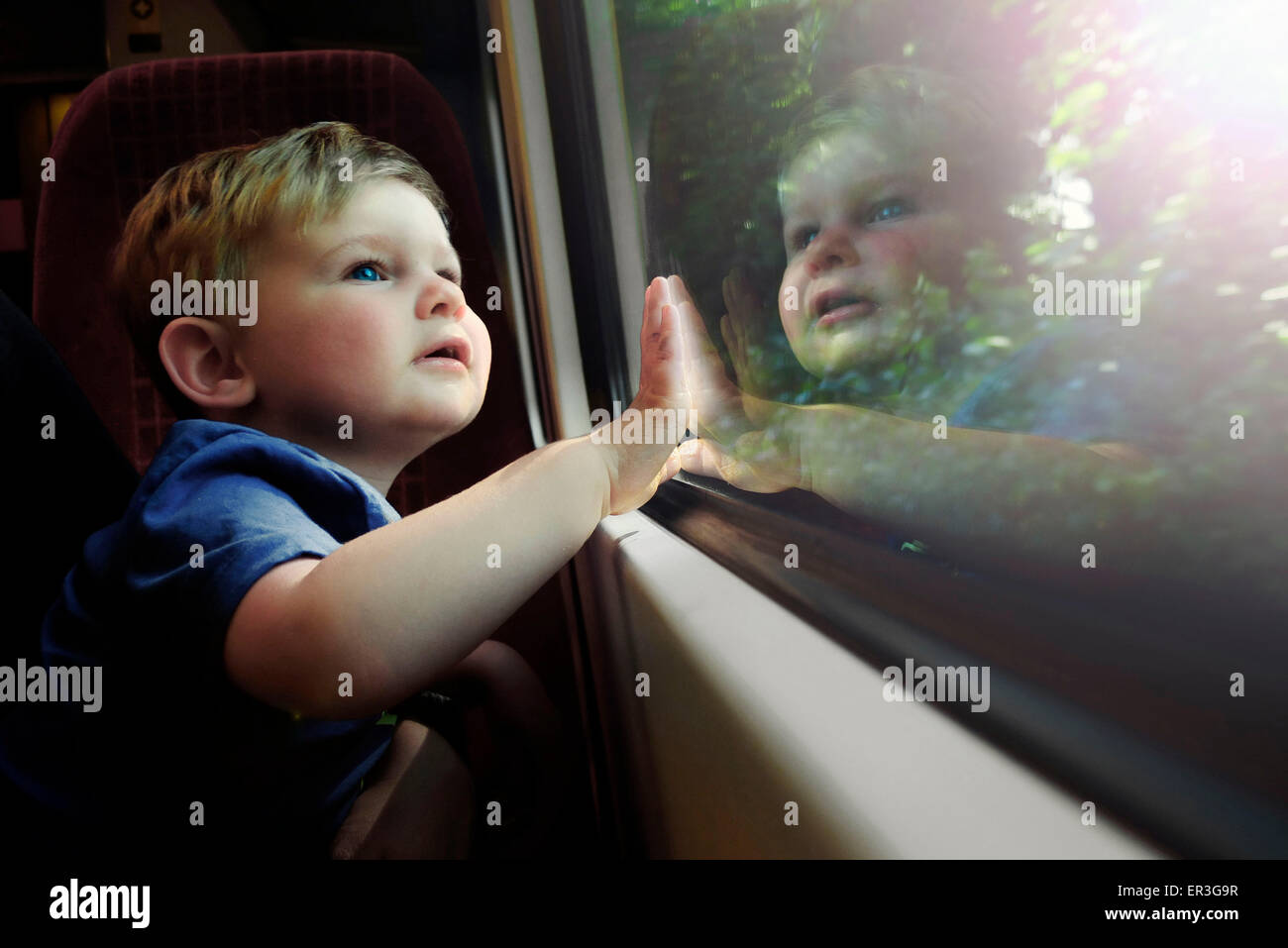 Baby boy gazing out train window in awe Stock Photo - Alamy