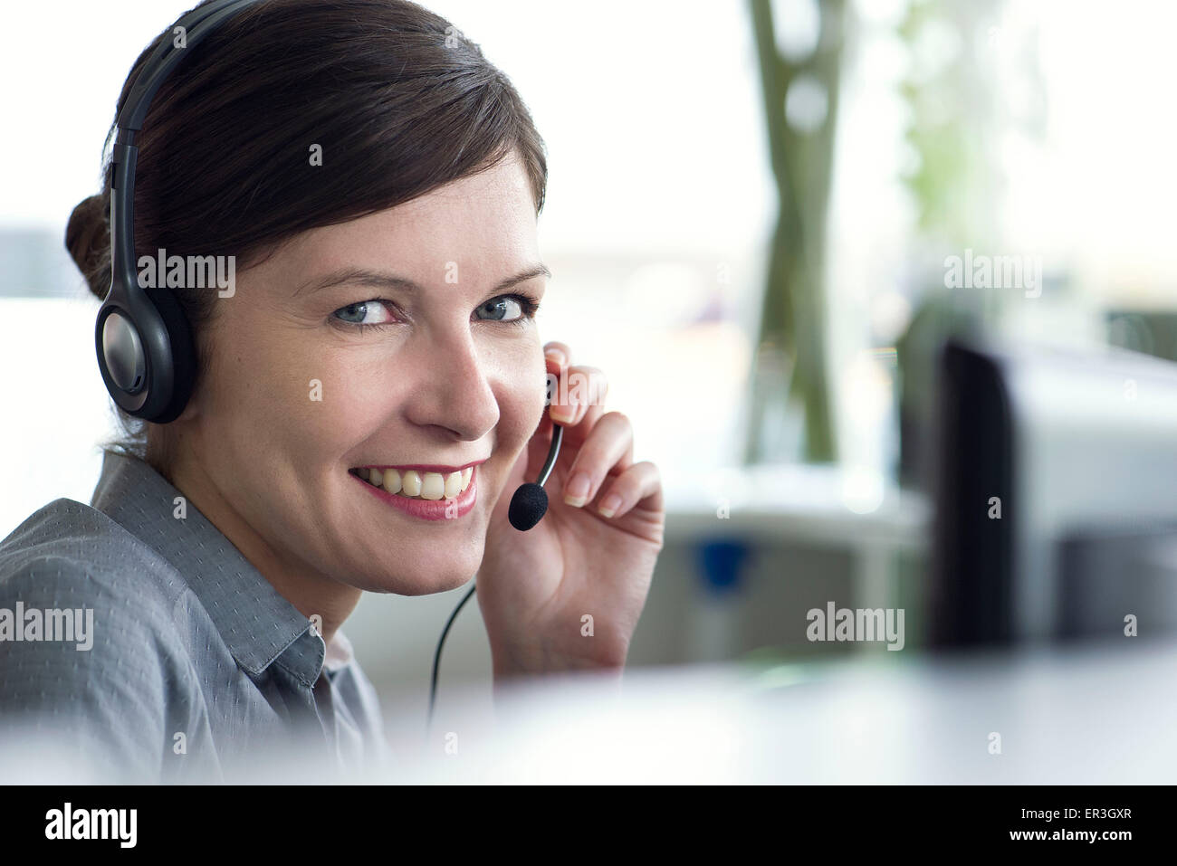 Receptionist smiling cheerfully Stock Photo - Alamy