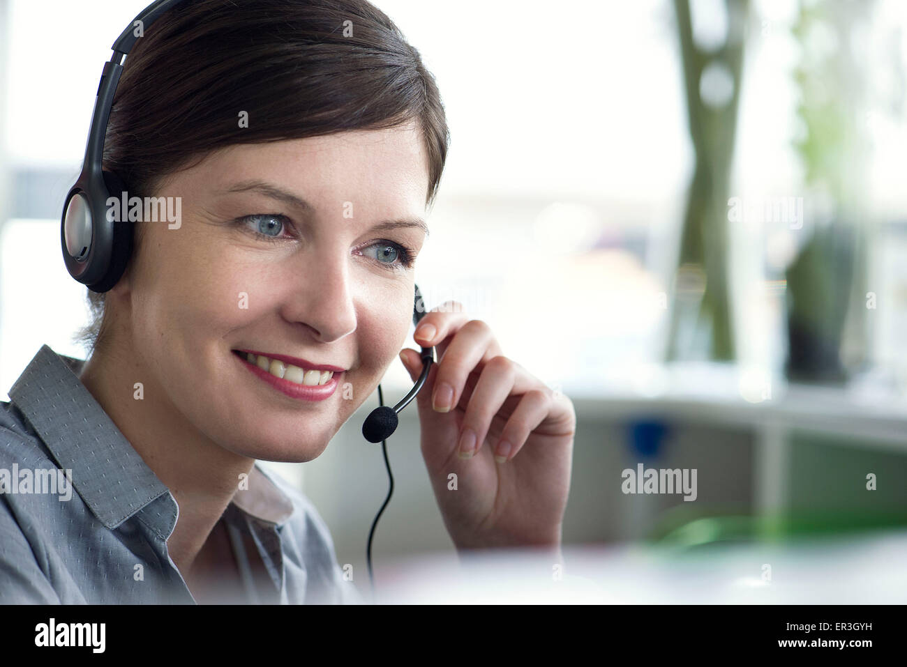 Receptionist using telephone headset Stock Photo - Alamy