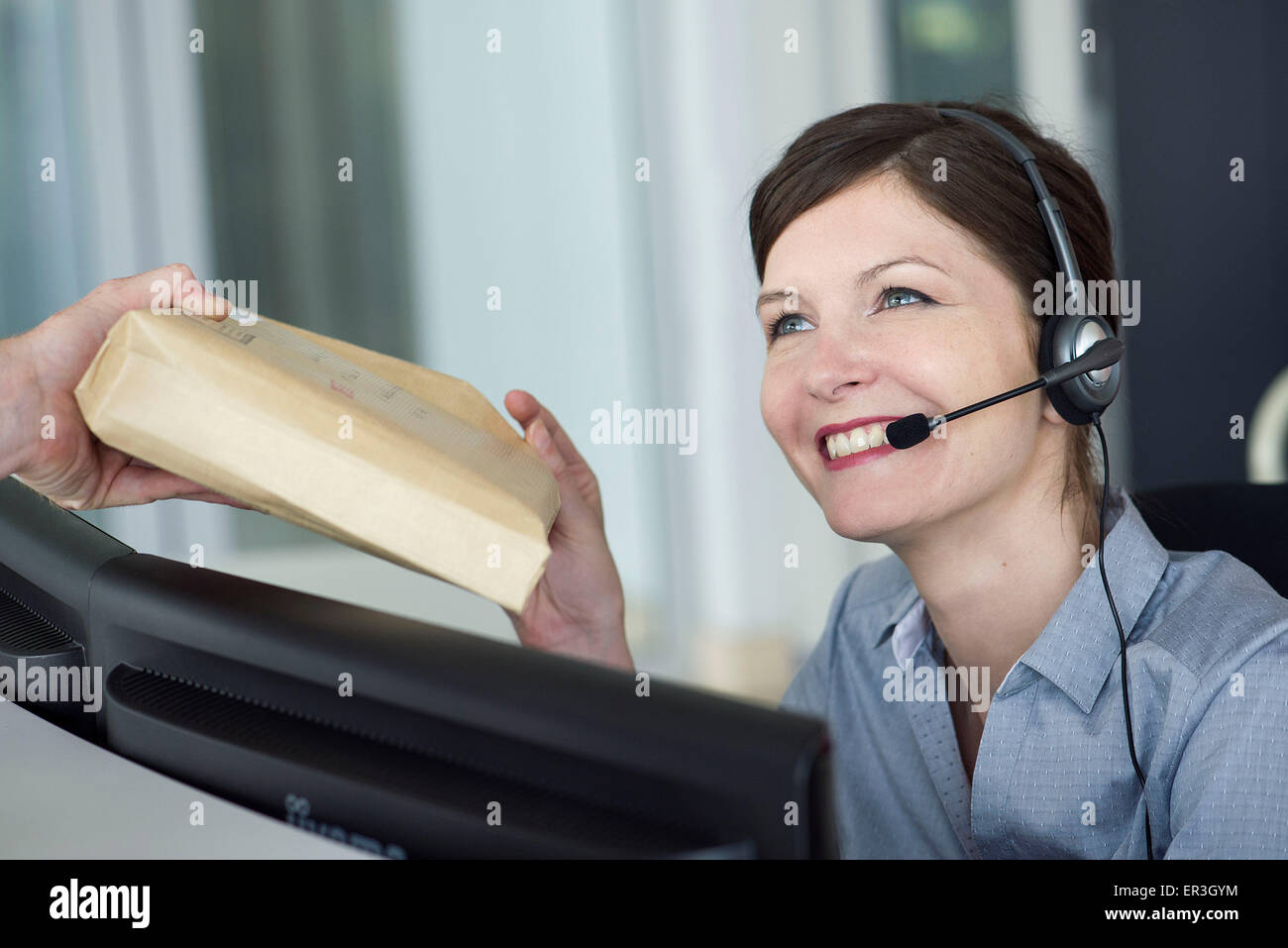 Receptionist accepting package from delivery person Stock Photo - Alamy