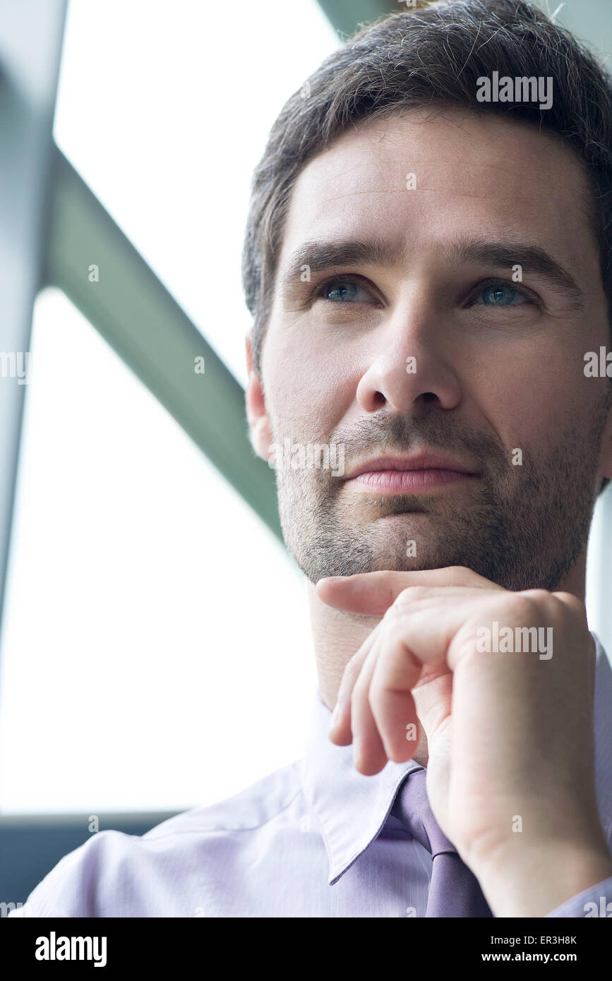 Businessman looking up in thought, portrait Stock Photo - Alamy
