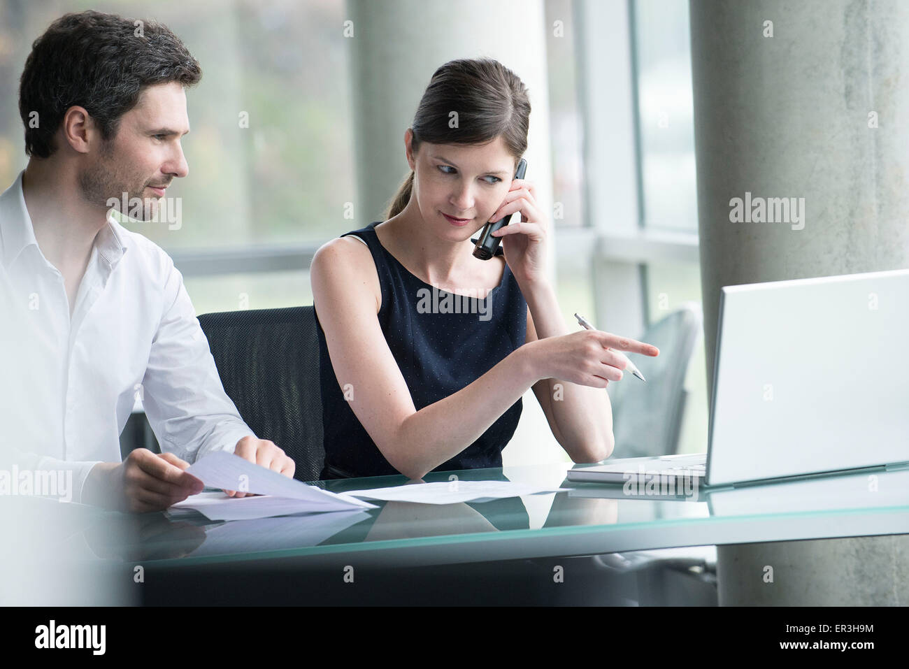Businesswoman directing colleague's attention to computer screen Stock ...