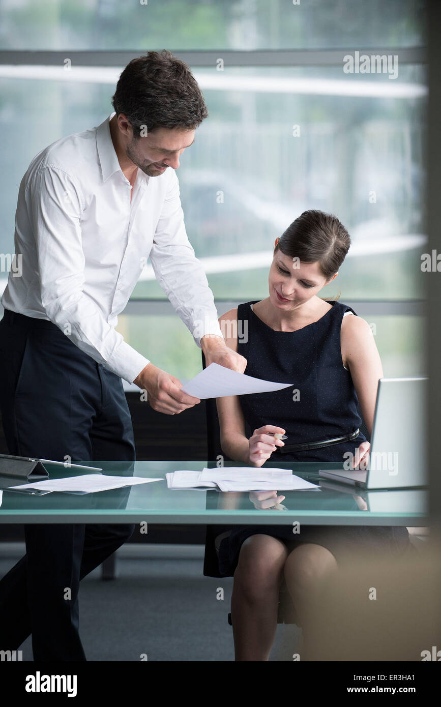 Businessman explaining document to colleague Stock Photo - Alamy