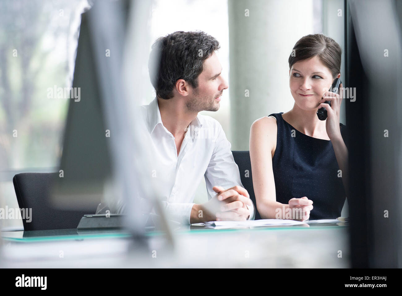 Businessman listening to associates phone call Stock Photo - Alamy