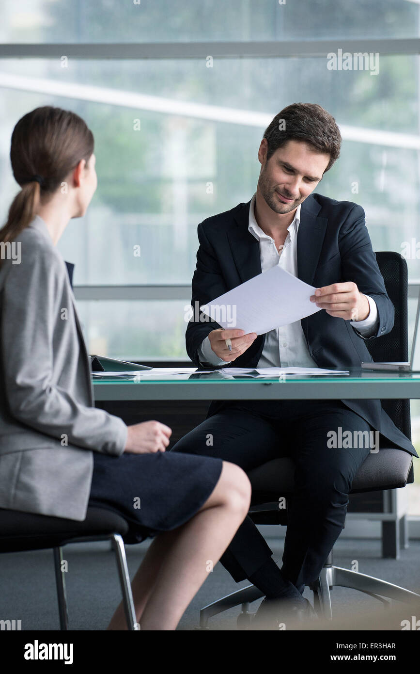 Businessman reviewing document with client Stock Photo - Alamy