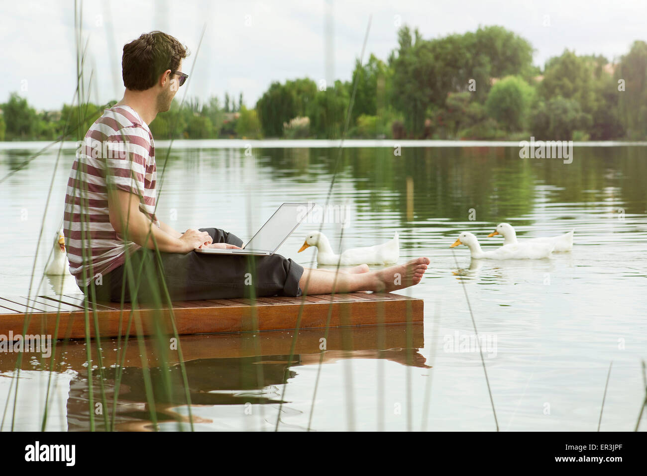 Man sitting on dock hi-res stock photography and images - Alamy