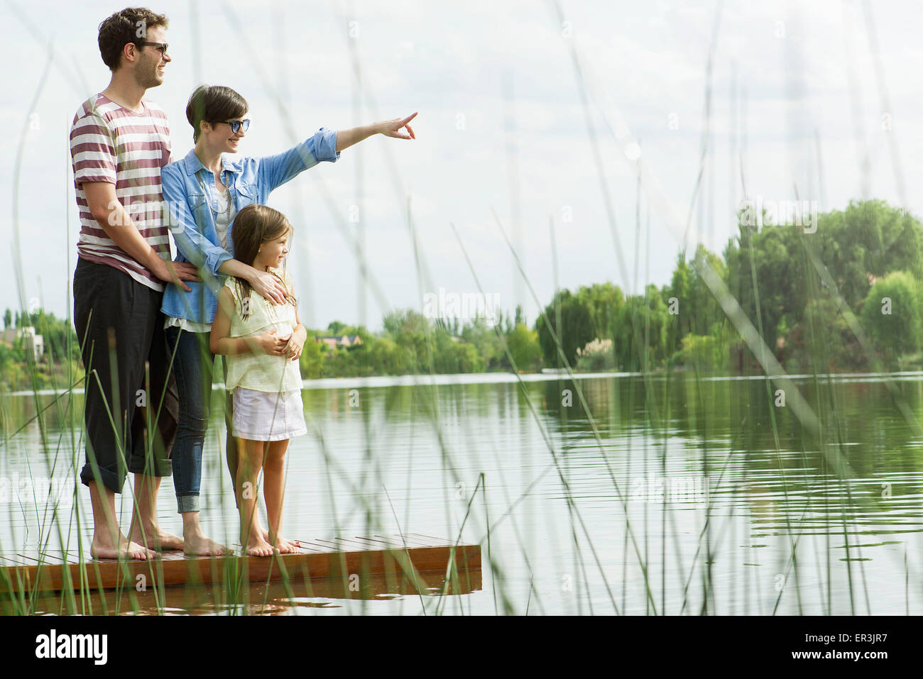 Family standing on dock looking into distance Stock Photo - Alamy