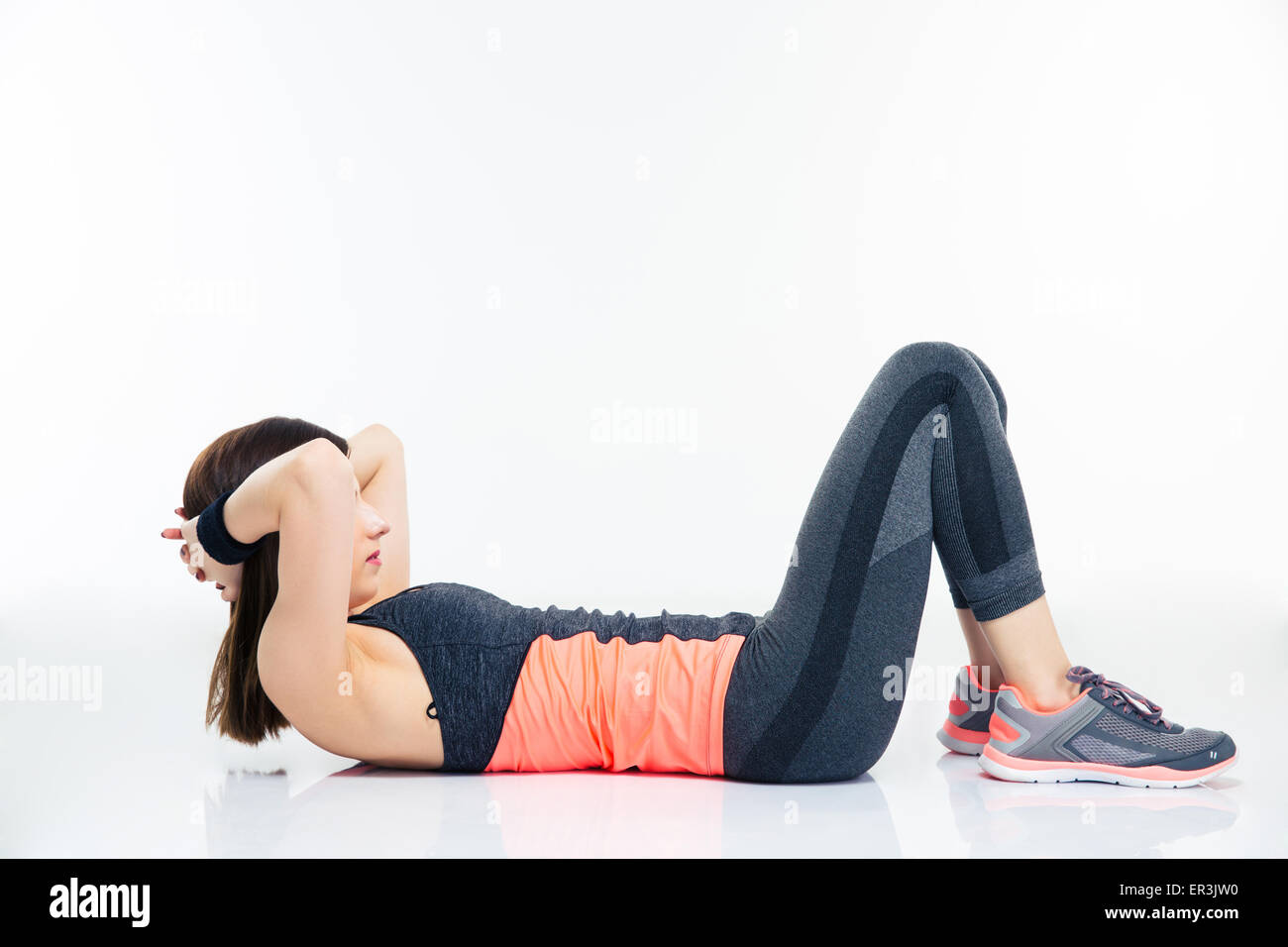 Fitness woman working out on the floor isolated on a white background ...
