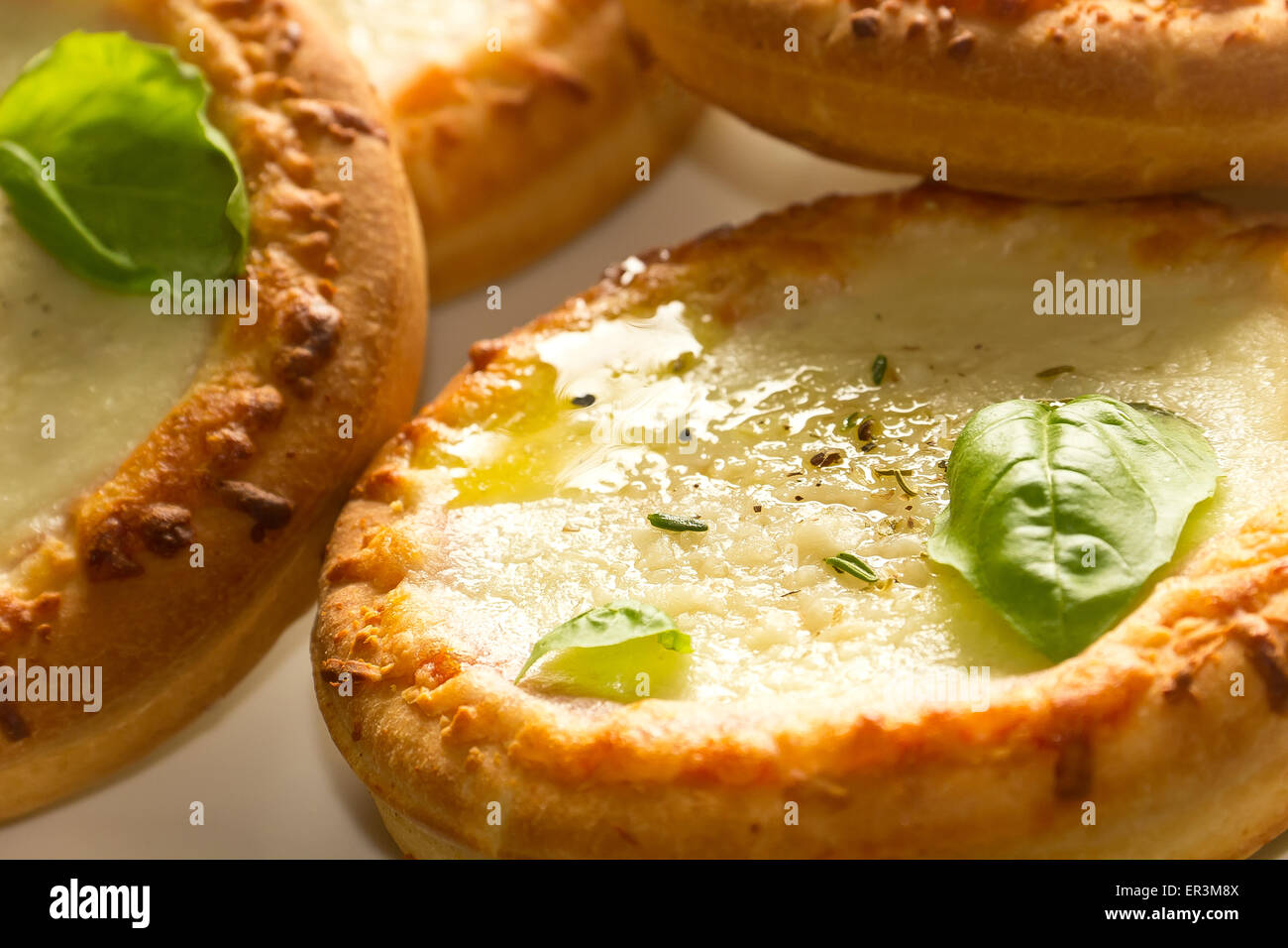 Pizzette, mini Italian pizzas served with fresh basil leaves Stock ...