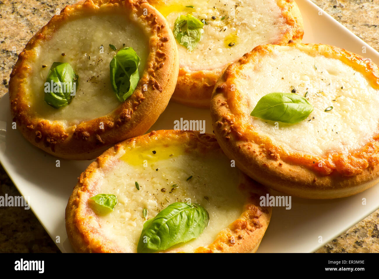 Pizzette, mini Italian pizzas served with fresh basil leaves Stock ...