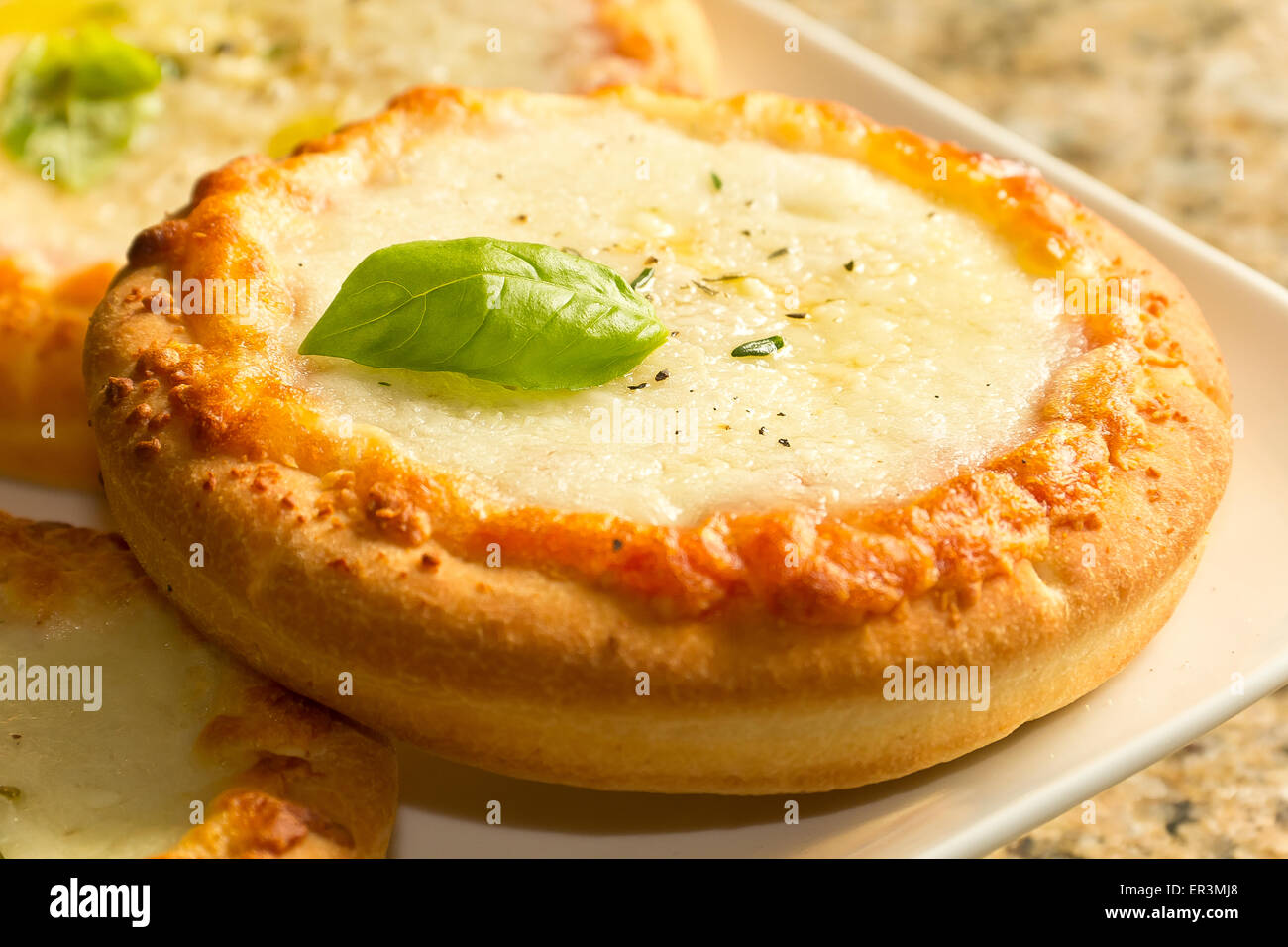 Pizzette, mini Italian pizzas served with fresh basil leaves Stock ...