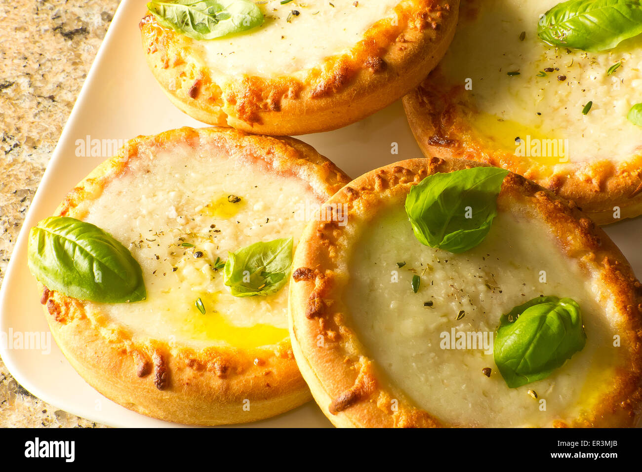 Pizzette, mini Italian pizzas served with fresh basil leaves Stock ...