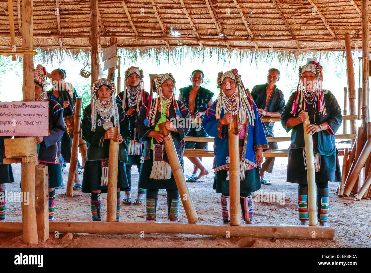 A group of Akha women and a men in a mountain village with traditional ...