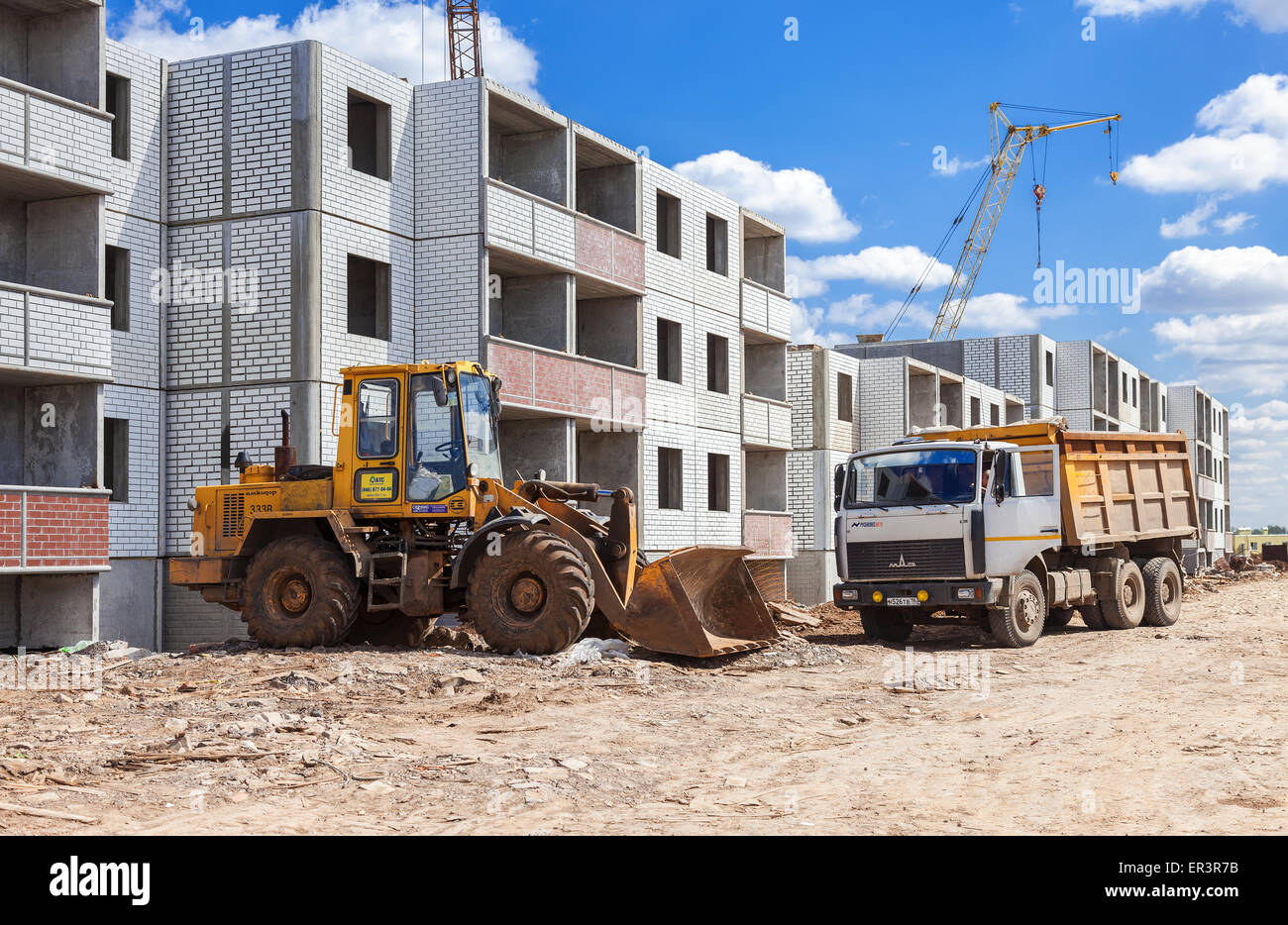 Construction technics stands near a residential building under ...