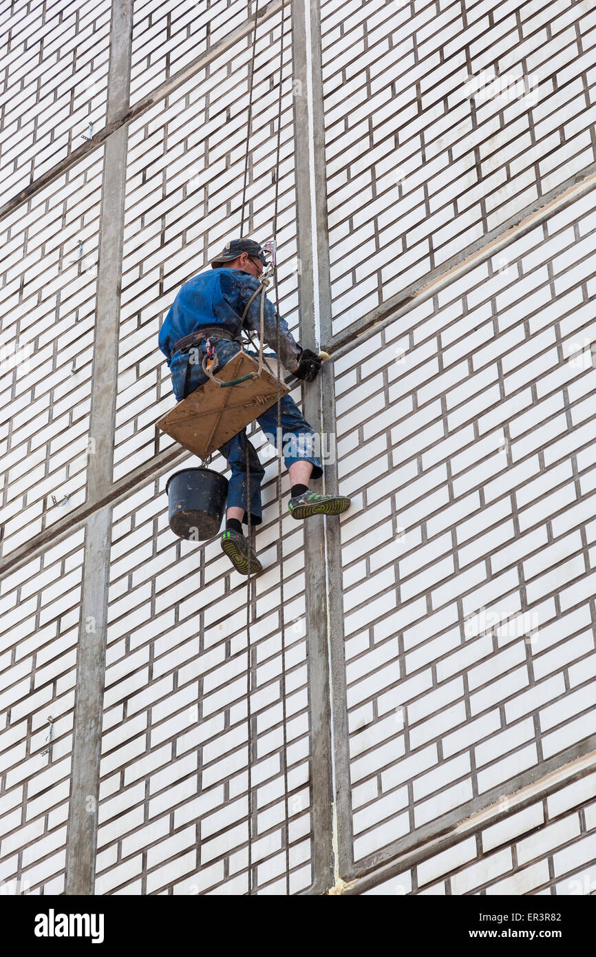 Construction worker working on side of house Stock Photo - Alamy