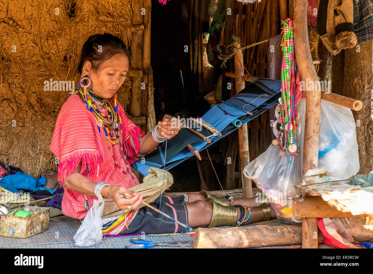 Woman from Palong tribe with traditional clothes, working on a loom ...