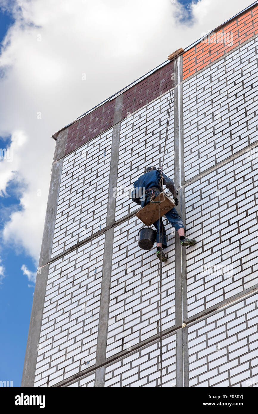Construction worker working on side of house Stock Photo - Alamy